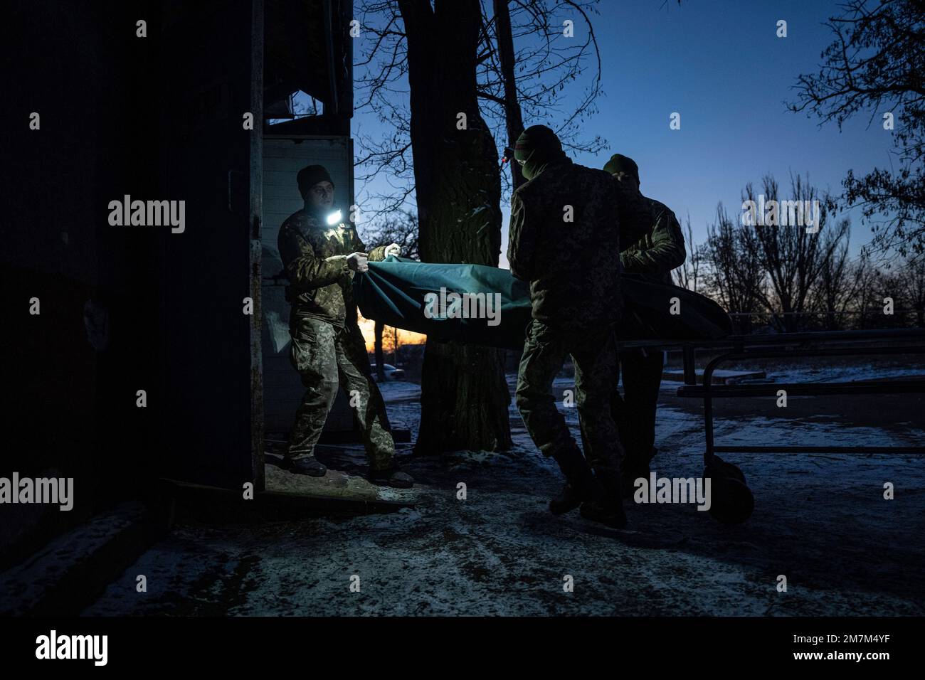 Ukrainian military medics carry a body of their killed comrade into a ...