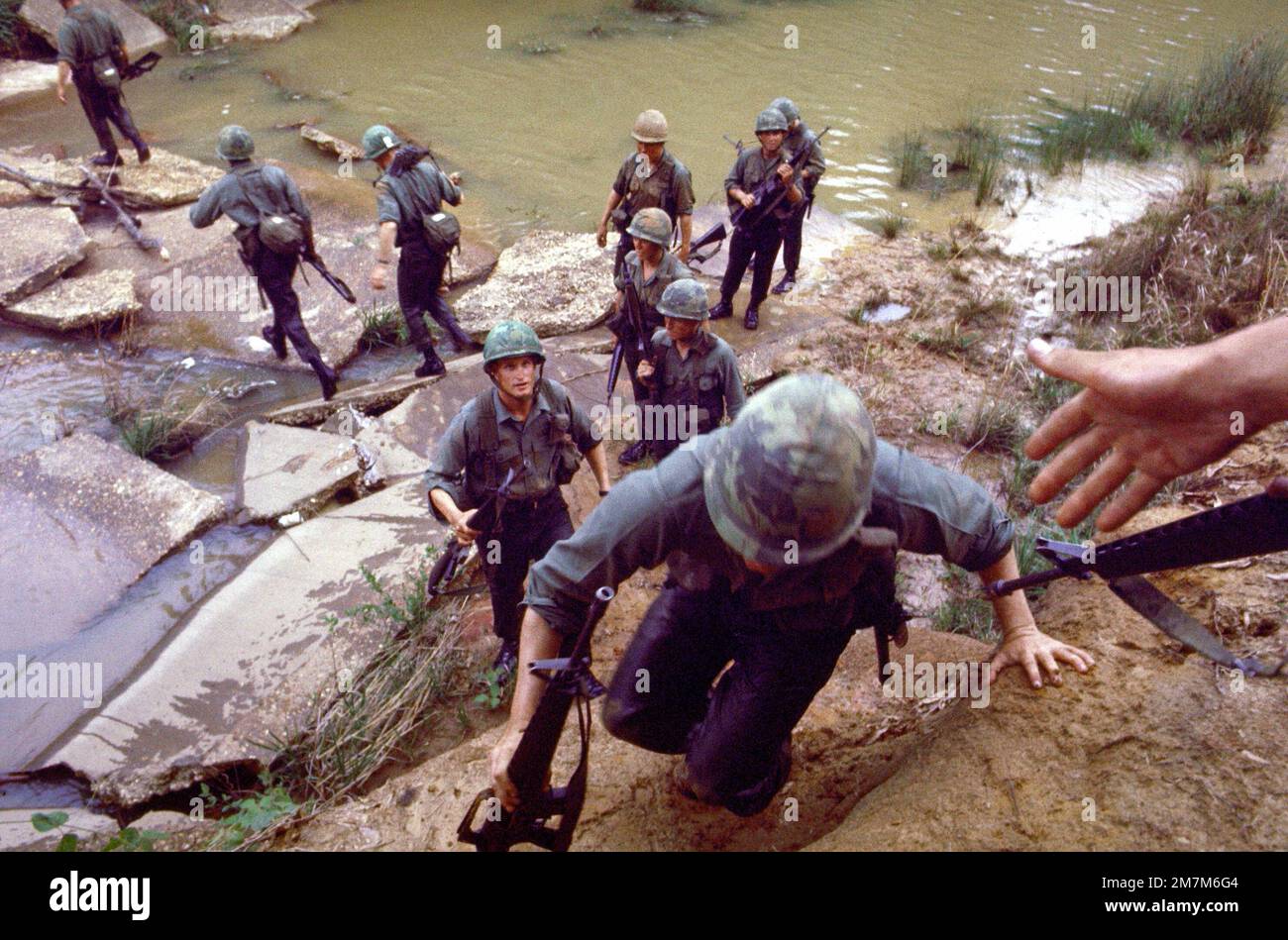 Army troops maneuver through difficult terrain during a training ...