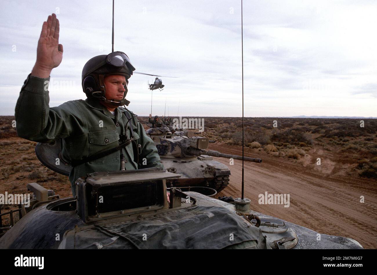 U.S. Army soldiers give hand signals from the turrets of their M-60 ...