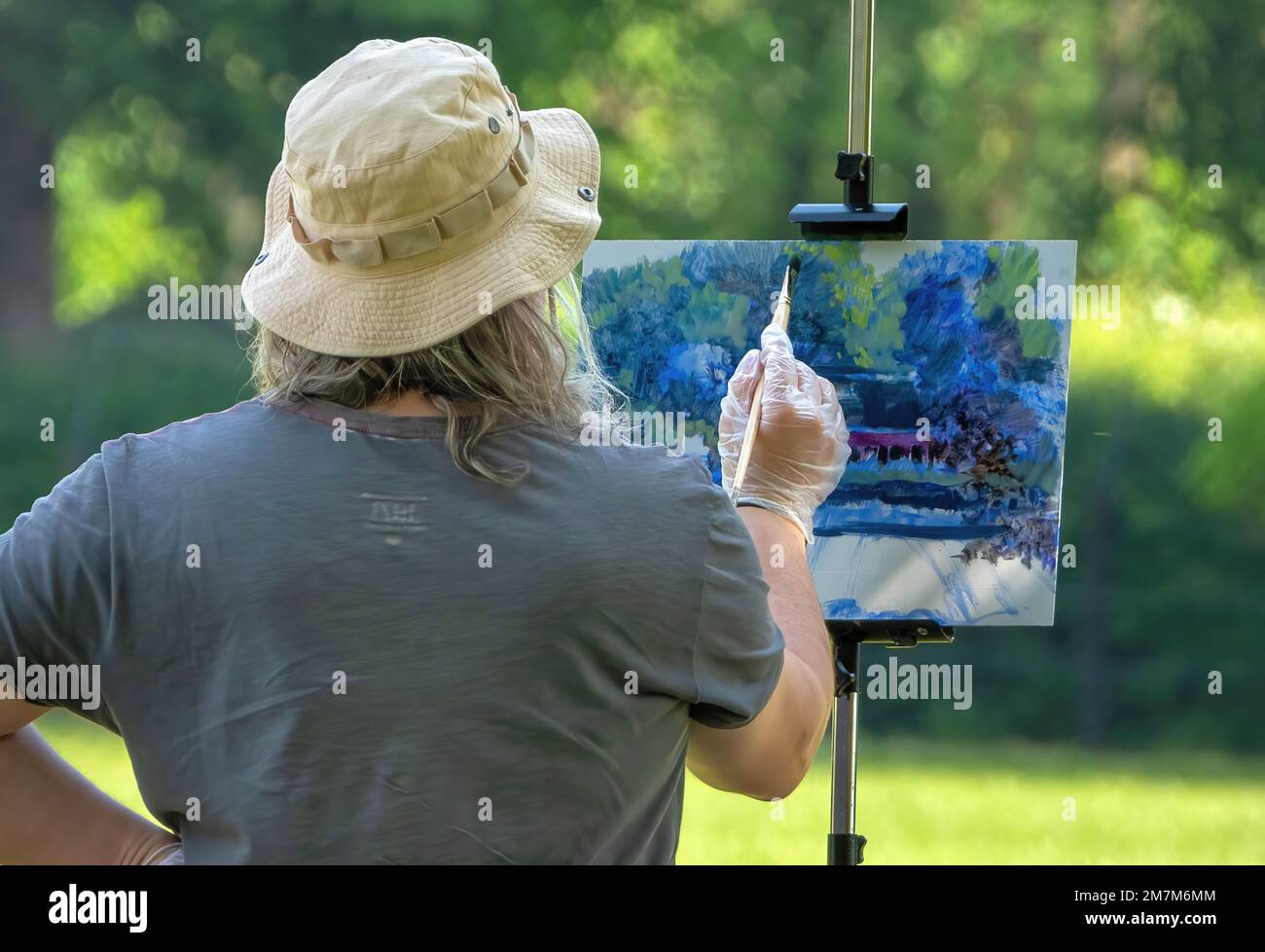 A person in a hat painting the nature Stock Photo - Alamy
