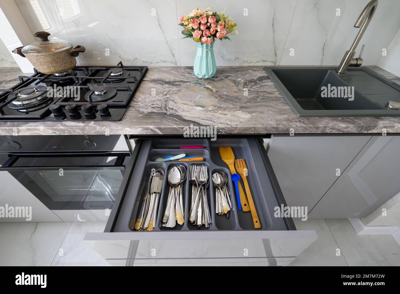 High angle frontal closeup view to open drawer of grey and white modern ...