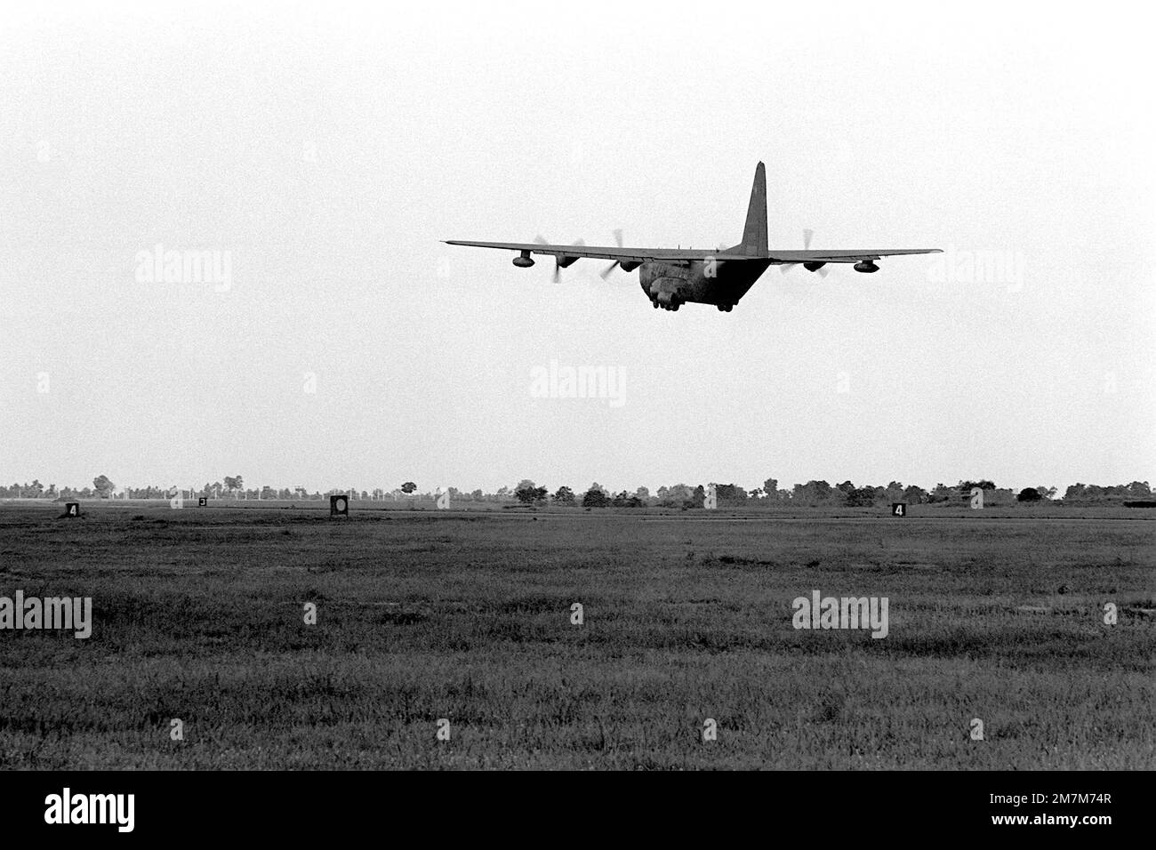 A left rear view of an AC-130A Hercules aircraft taking off. Five ...