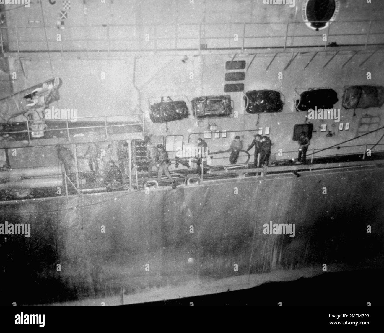 A firefighting team moves a hose into position to fight a fire near the ...