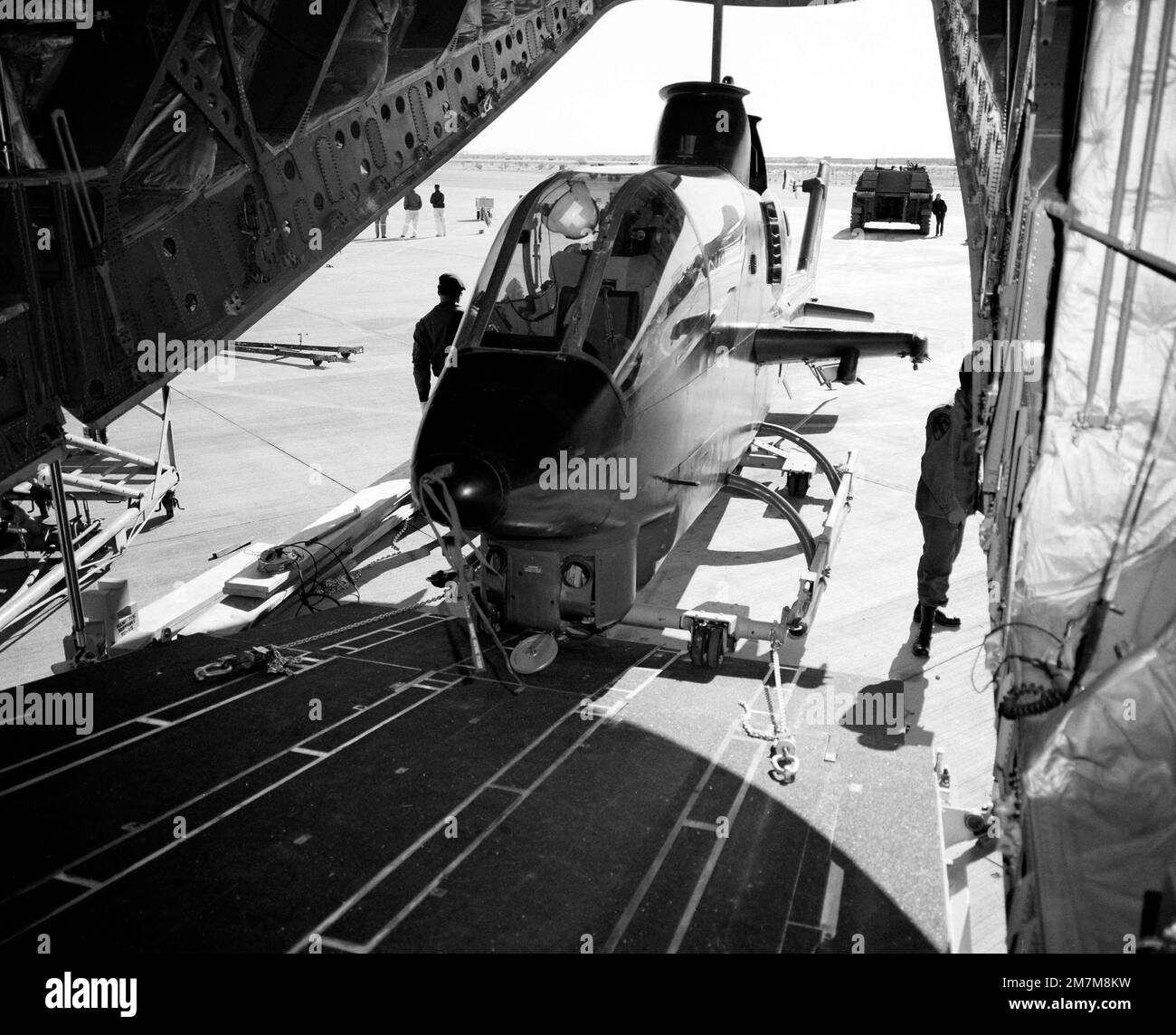 An AH-1G Cobra helicopter is offloaded from a YC-15 aircraft during a ...