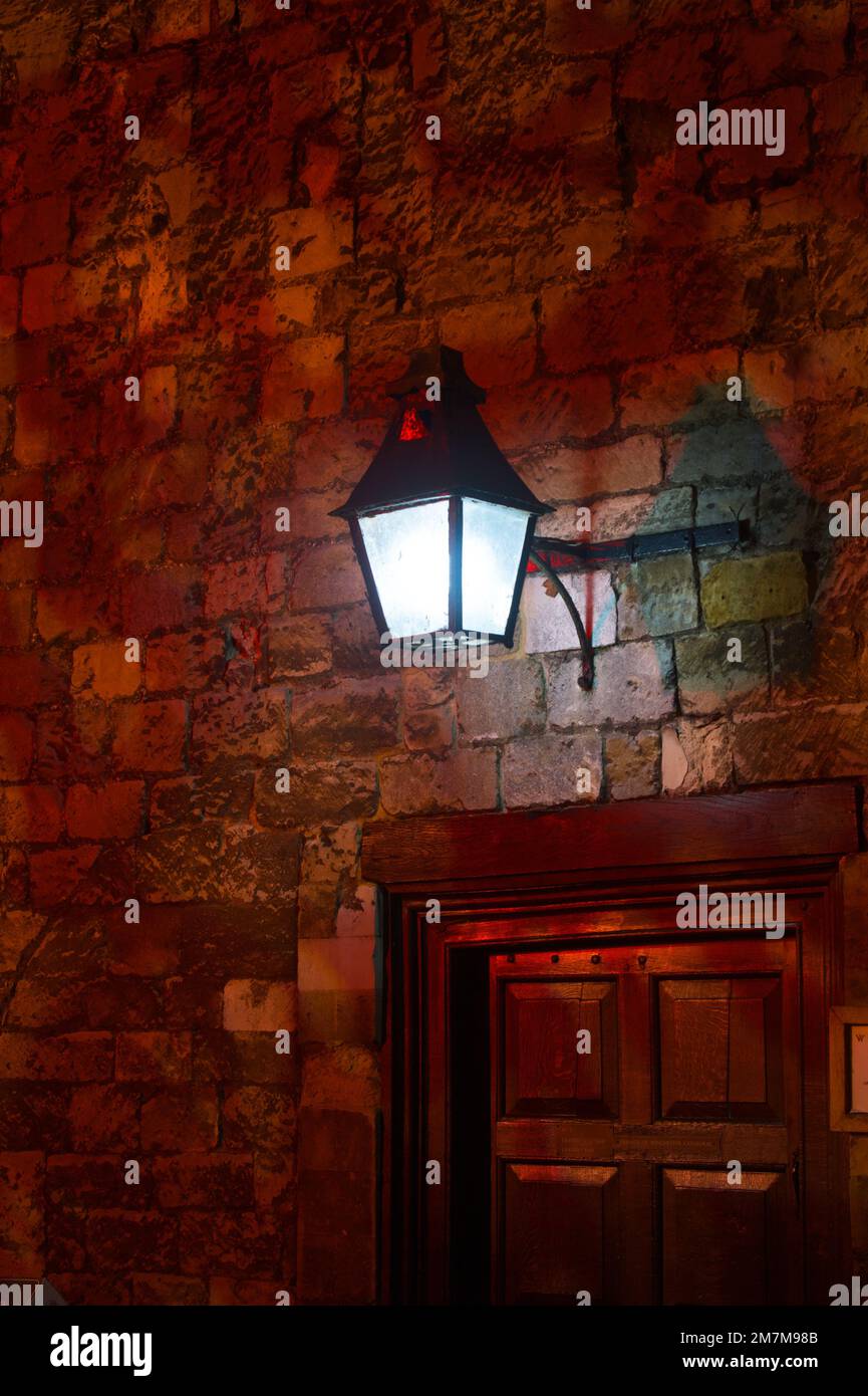 Single Lantern, Light Iluminating A Wooden Door Set In A Medieval Wall ...