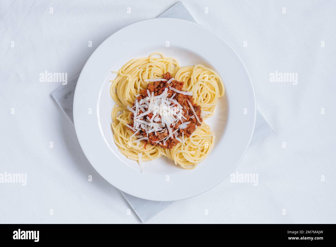 Top view of Bolognese spaghetti with parmesan cheese on top in white ...