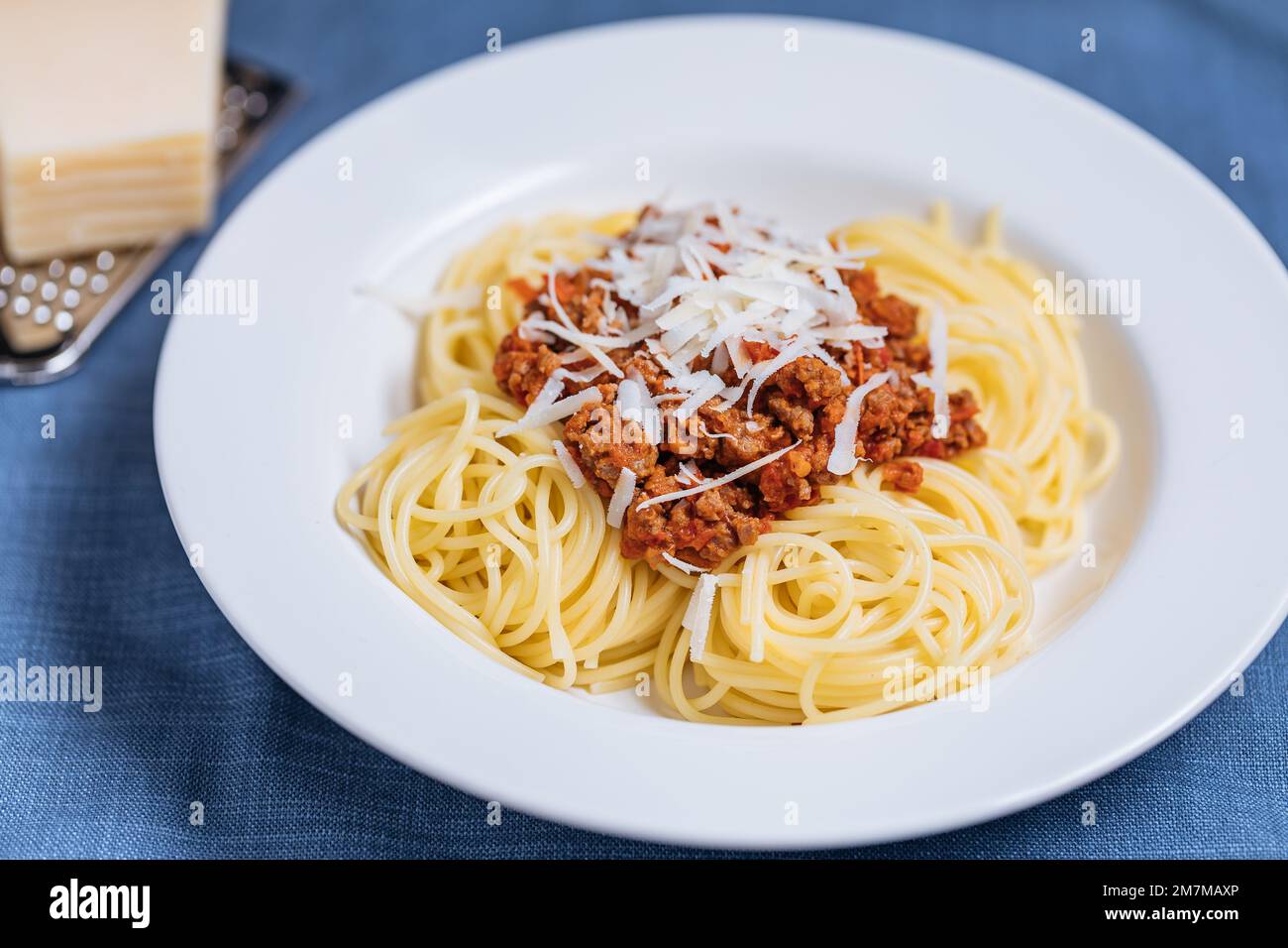 Bolognese spaghetti with parmesan cheese on top in white plate. Simple ...