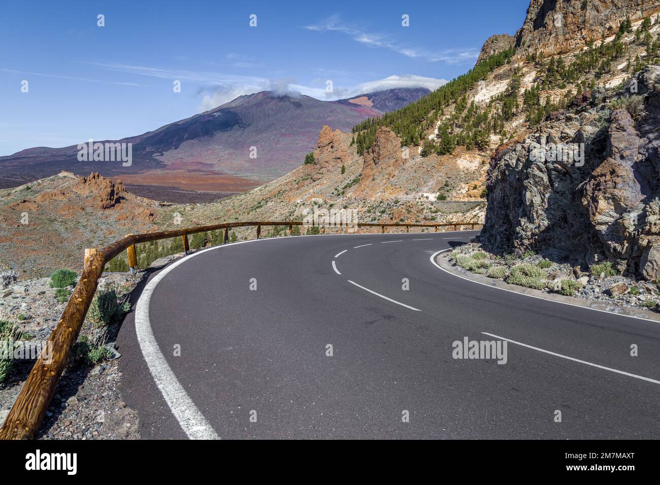 Purple tinted volcano with its peak covered by a cloud, viewed from the ...