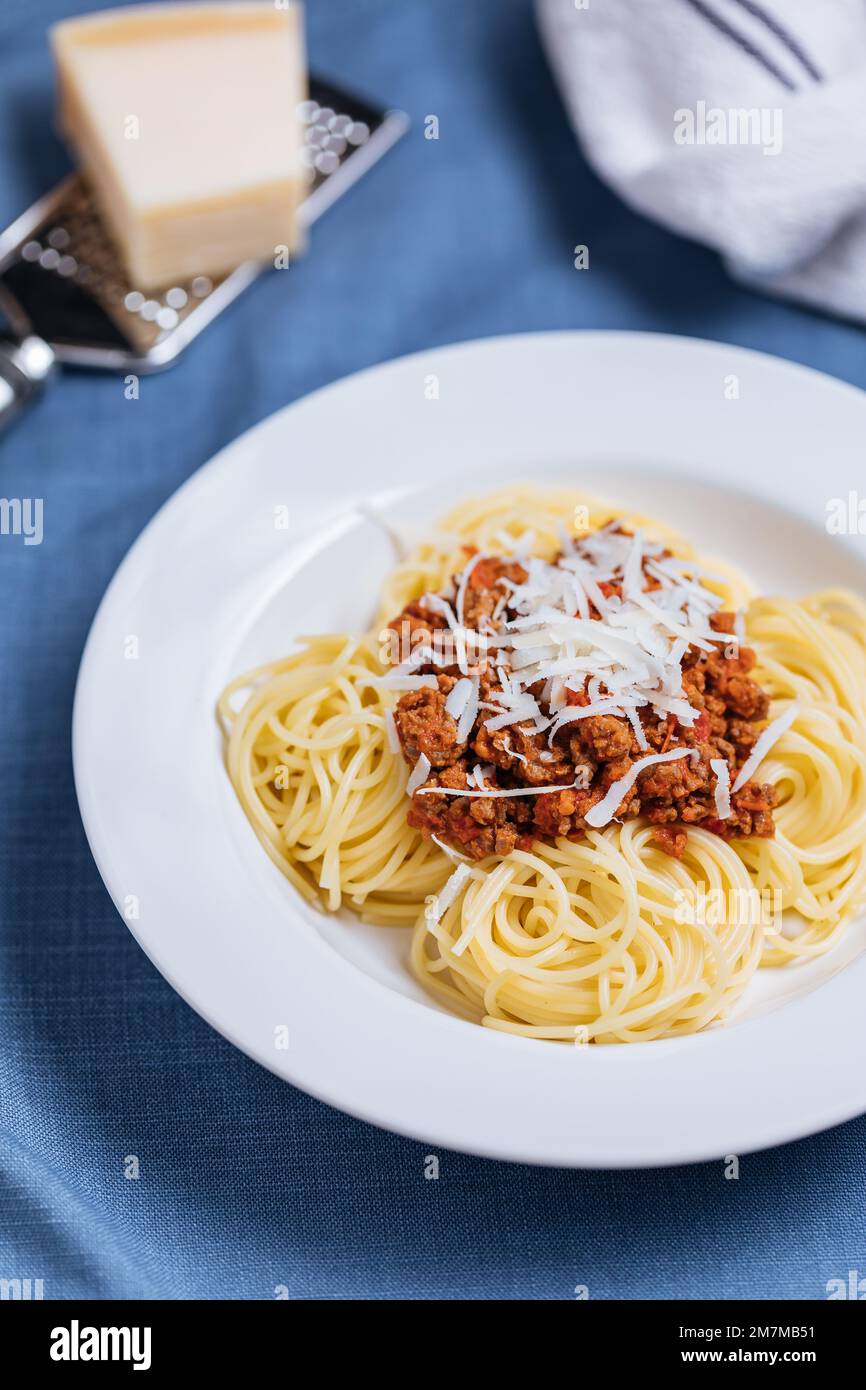 Bolognese spaghetti with parmesan cheese on top in white plate. Simple ...