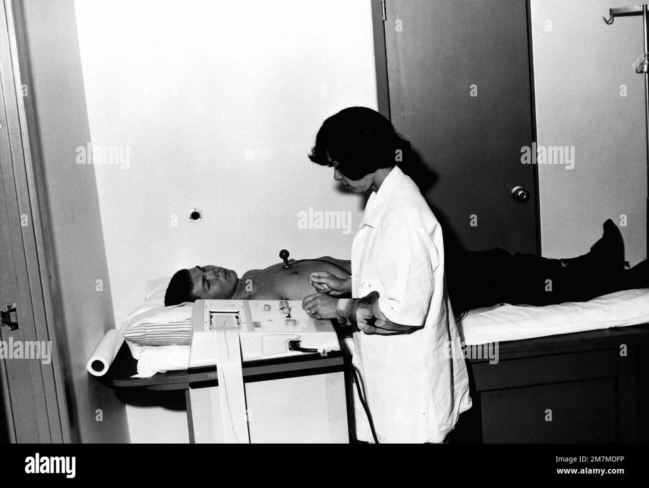 An EKG technician prepares and takes readings of a patient on the ...