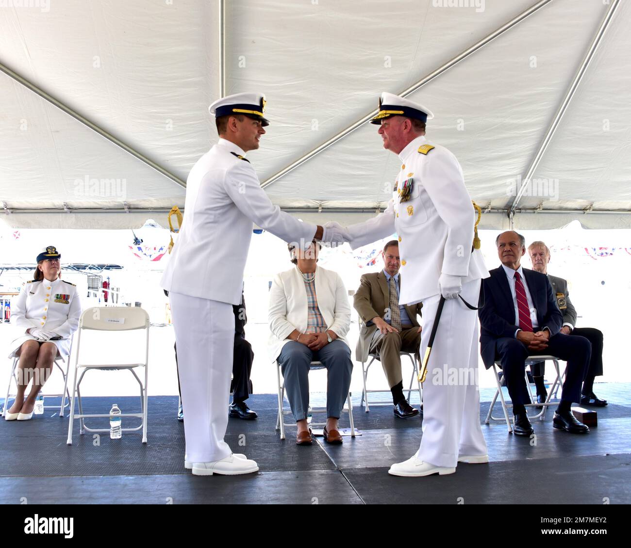Rear Adm. Brendan McPherson (right) places the Coast Guard Cutter Pablo ...