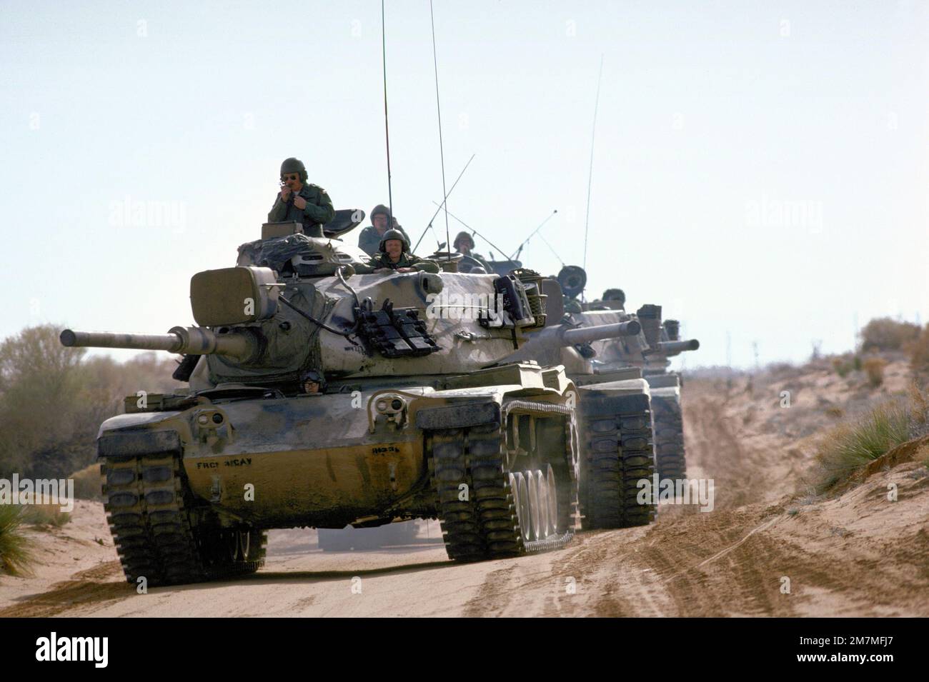 A convoy of M-60 main battle tank moves down a road during a training ...