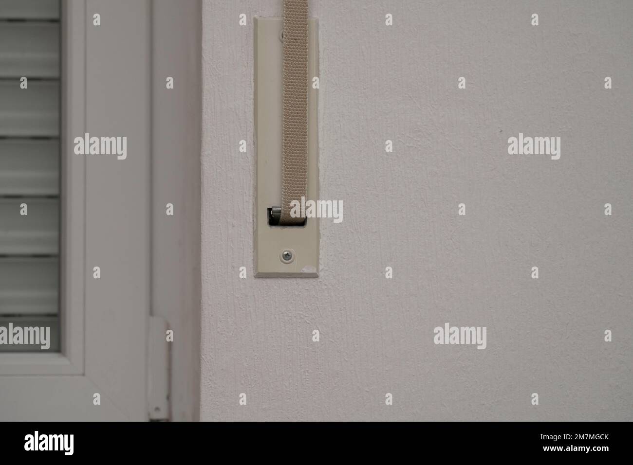 blind closure mechanism on the white wall near the window close-up ...