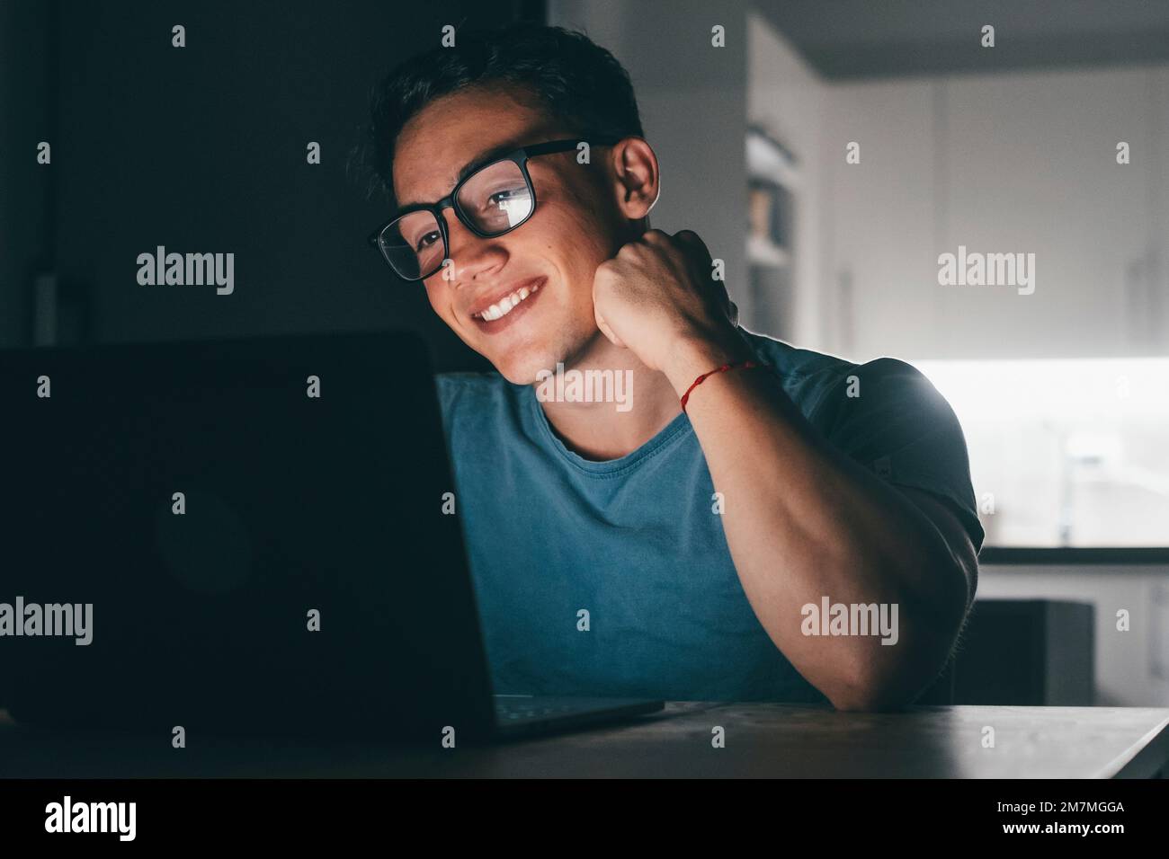 One young teenager studying and working at home at night on the table ...