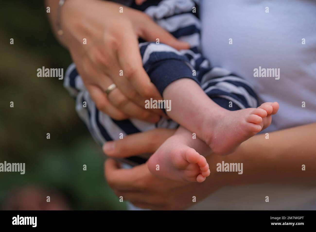 Mother's hands keep the baby's feet close-up Stock Photo - Alamy