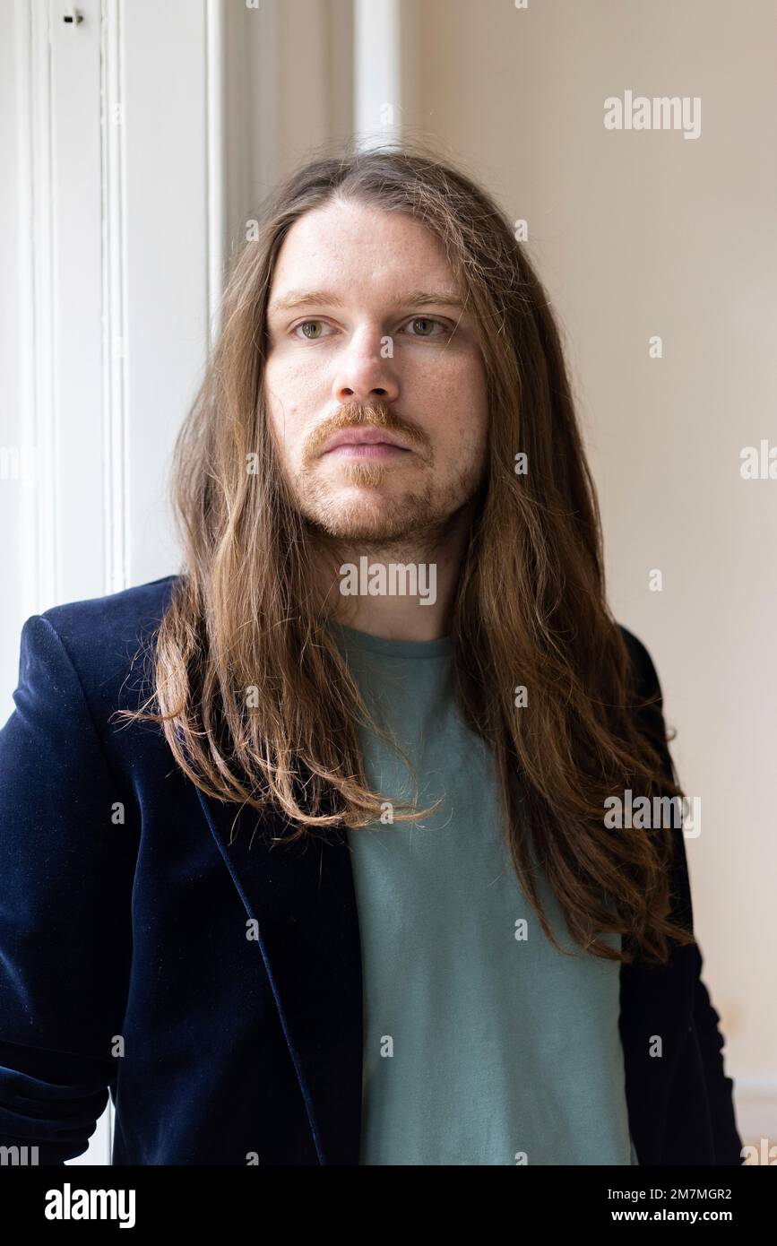 Portrait of long haired man in window frame of old building Stock Photo ...