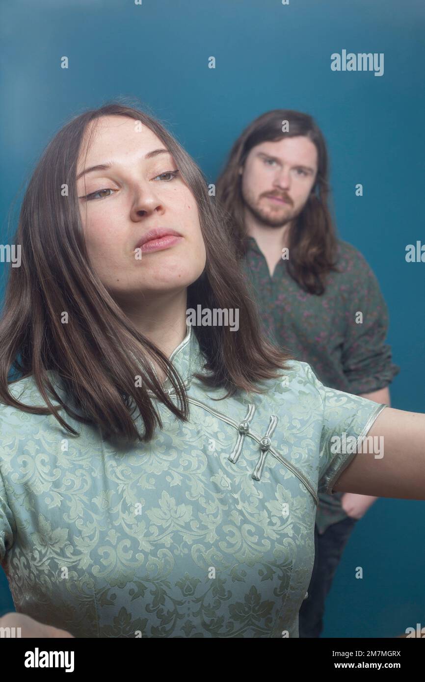 A young man stands behind a woman who looks into a mirror held up high ... A young man stands behind a woman who looks into a mirror held up high ...