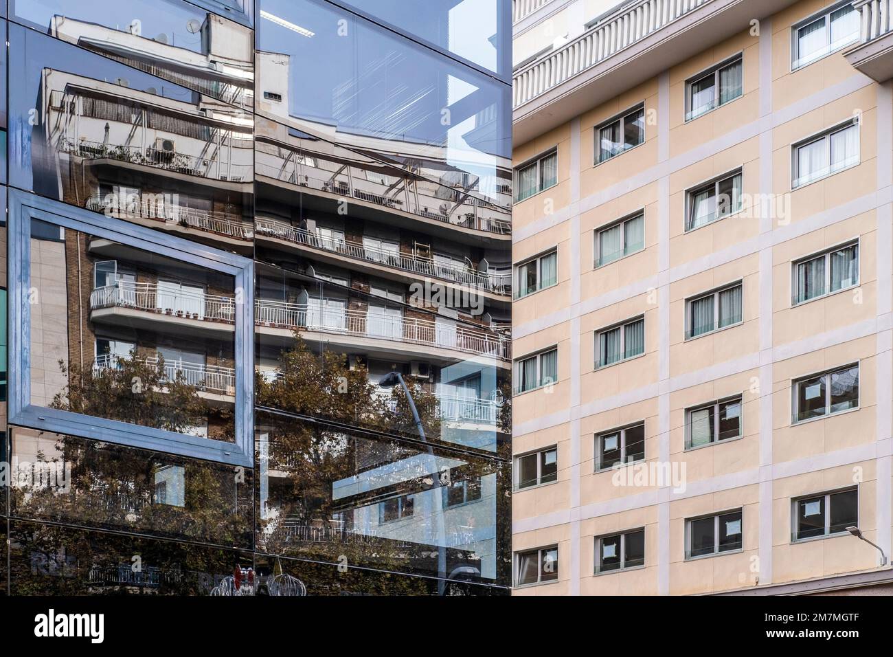 apartment buildings reflected in a building with a mirrored facade ...