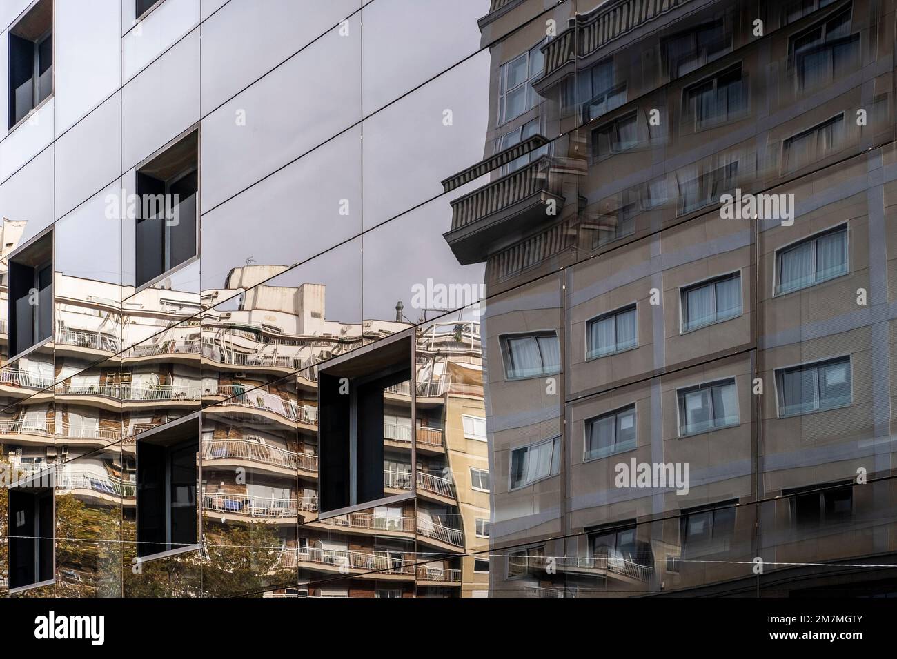 Apartment buildings reflected in a building with a mirrored facade hi ...