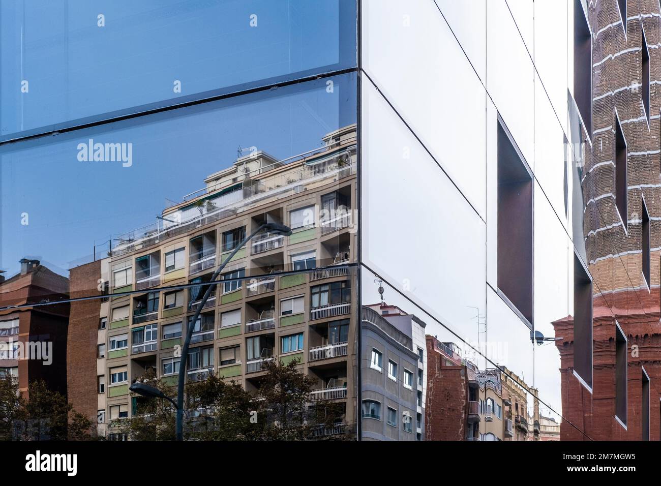 apartment buildings reflected in a building with a mirrored facade ...