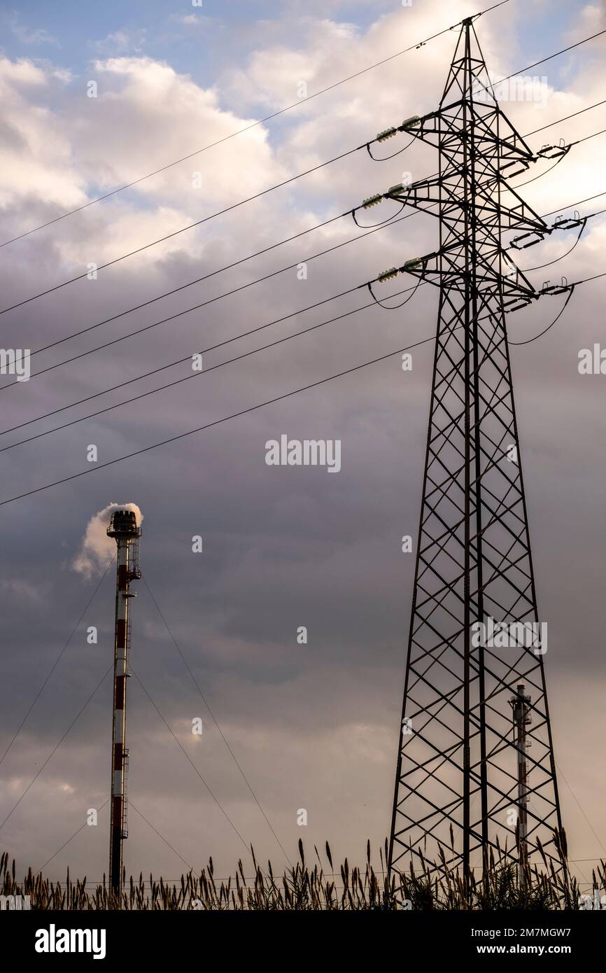 High voltage cable pylons in a dramatic cloudy sunset Stock Photo - Alamy