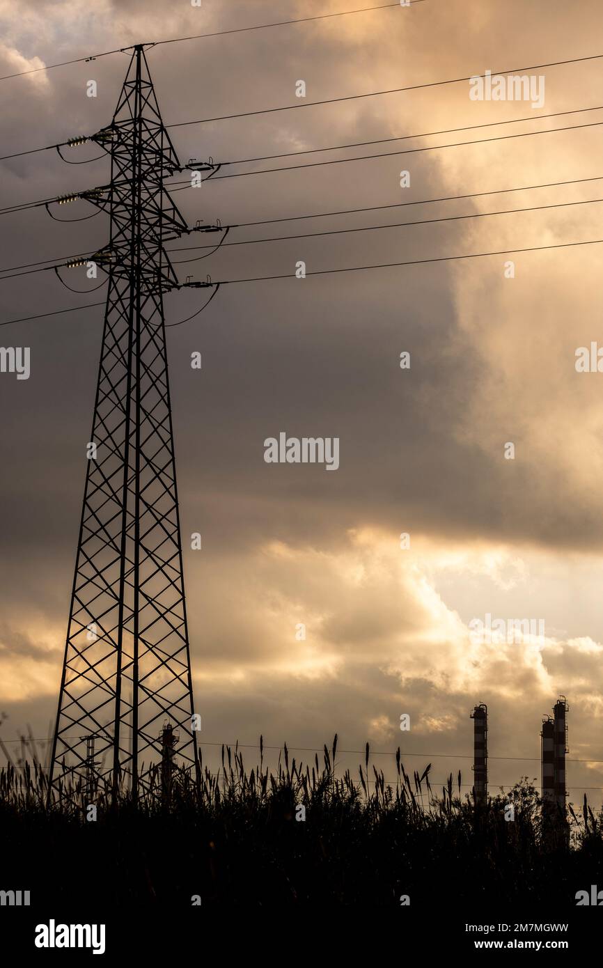 High voltage cable pylons in a dramatic cloudy sunset Stock Photo - Alamy