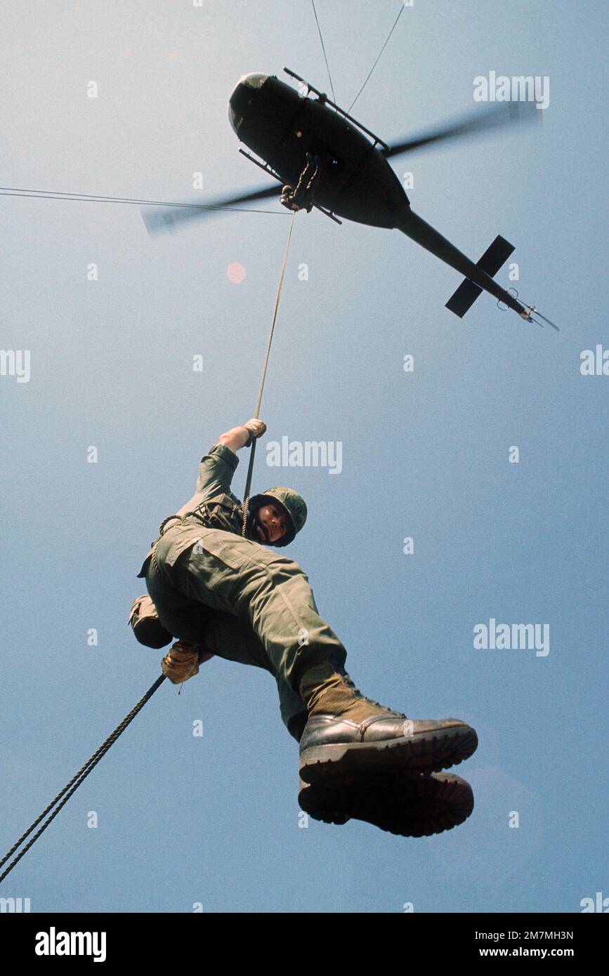 A US Army soldier rappels from a UH-1 Iroquois helicopter during a ...