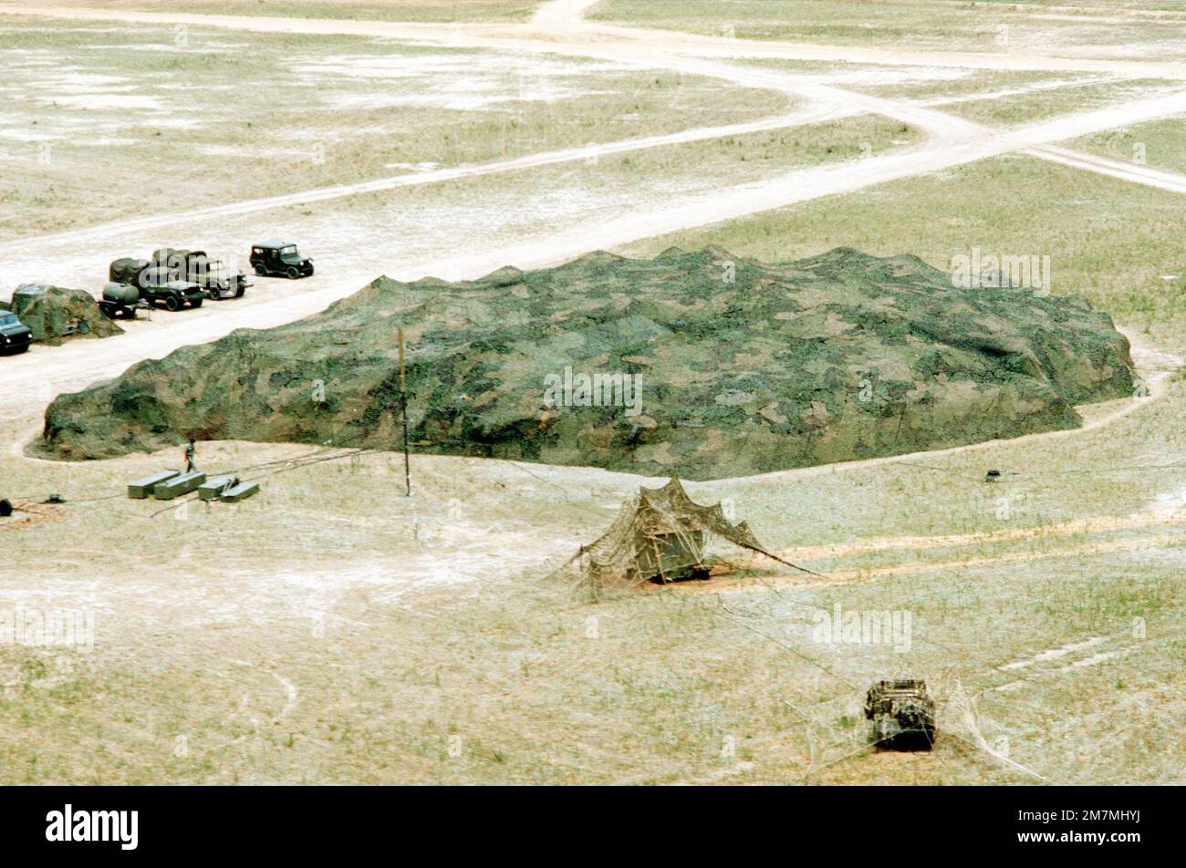 An aerial view of a camouflaged tent complex in use during joint ...