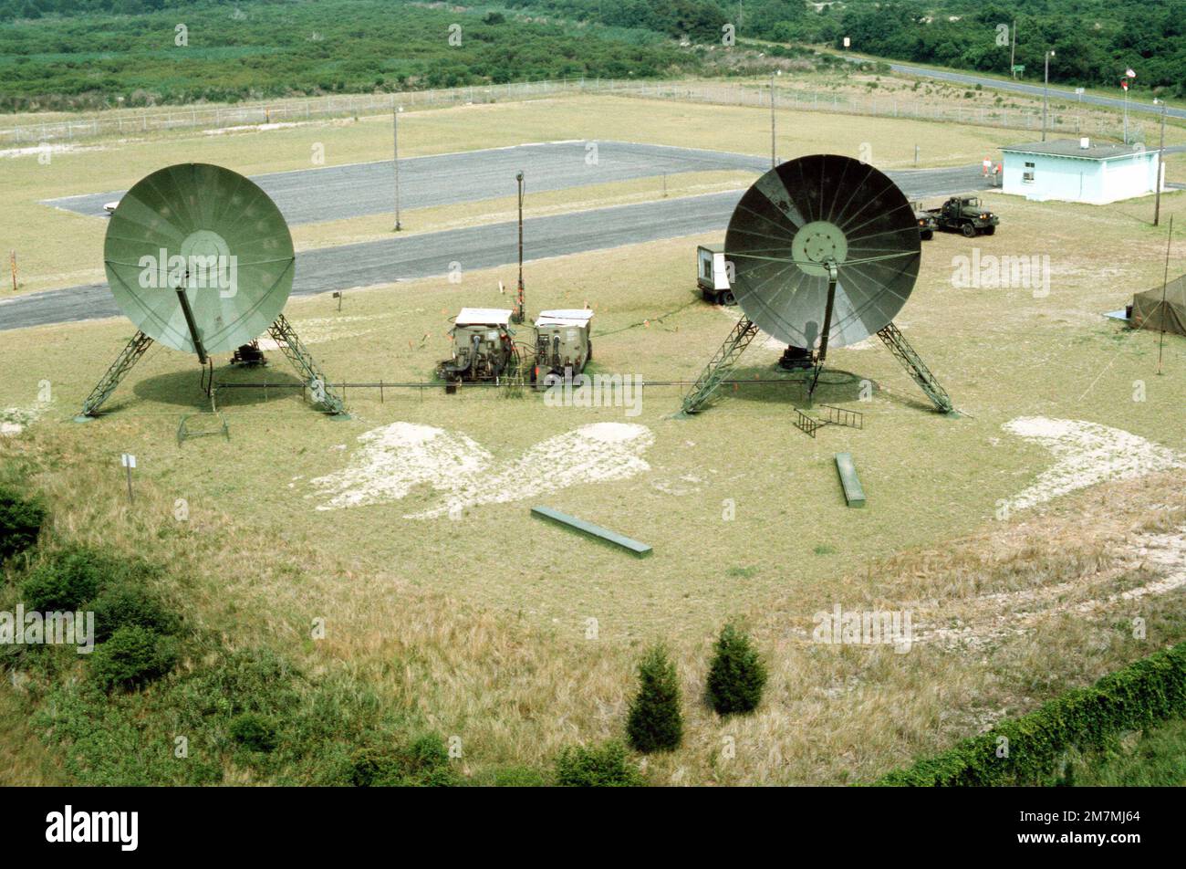 An aerial view of two large dish-shaped radar antennas in use during ...