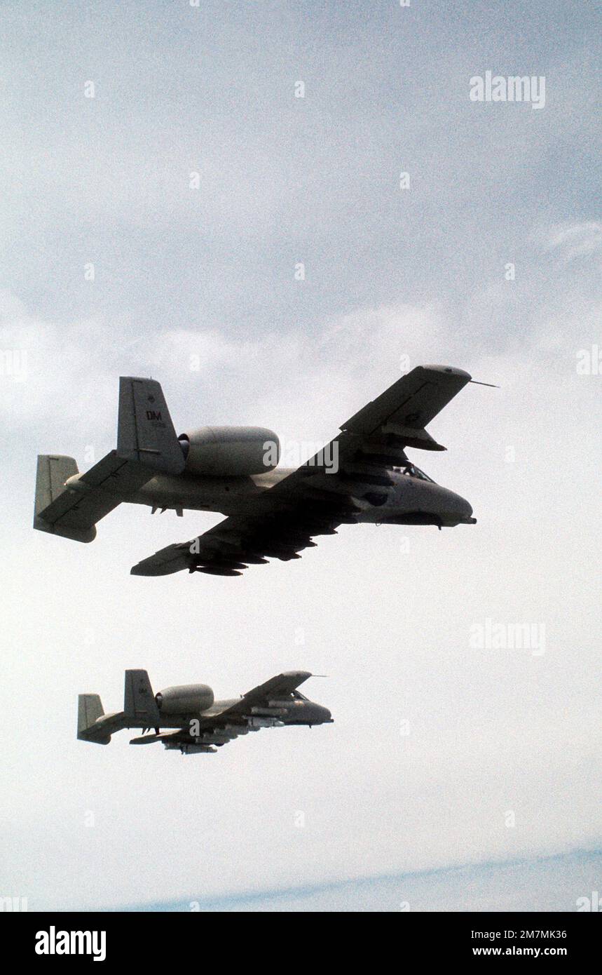 An air-to-air underside view of two A-10 Thunderbolt II aircraft. The A ...