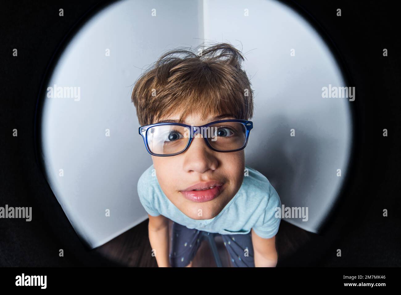 An exaggerated close up portrait of a funny little boy with glasses ...