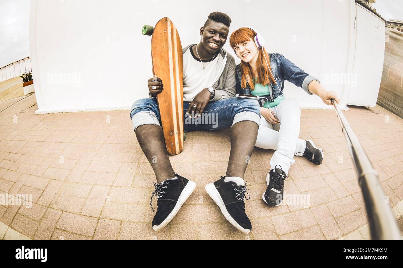 Multiracial couple in love taking selfie having fun together outdoors ...