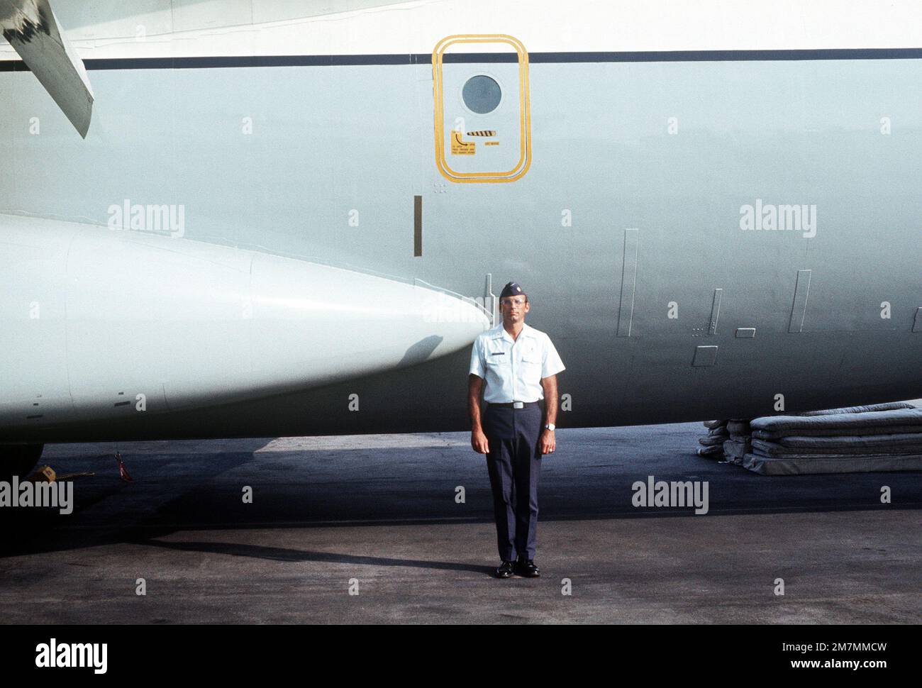 A military person stands beside a YC-141-B aircraft to show the ...