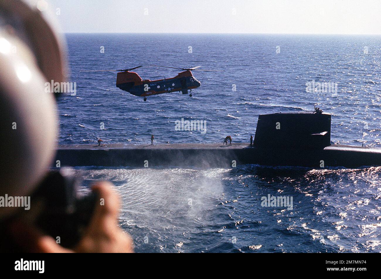An HH-46A Sea Knight helicopter hovers over the nuclear-powered ...