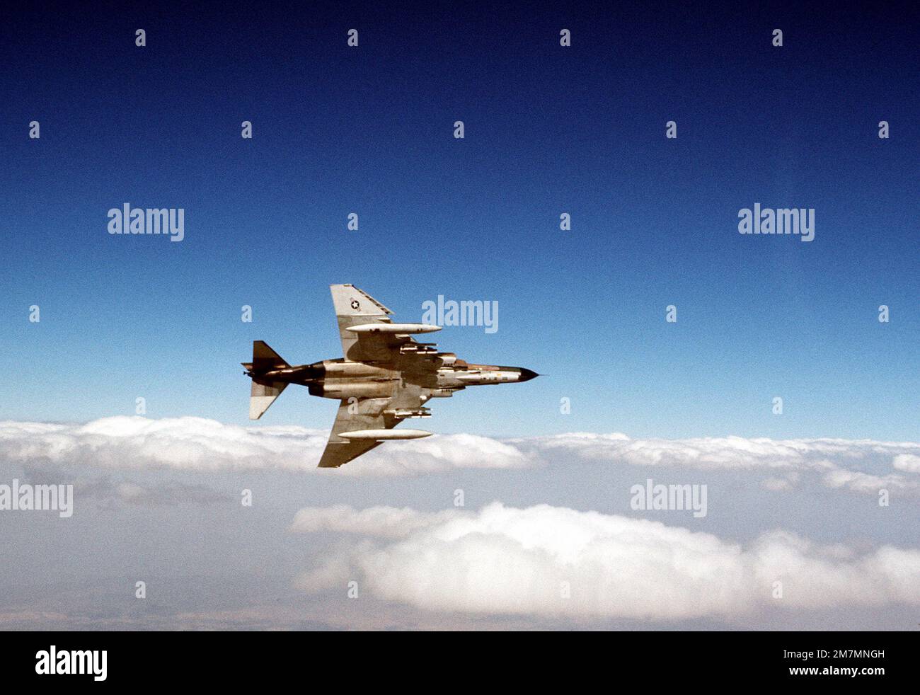 An underside view of an F-4 Phantom II aircraft banking sharply to the ...