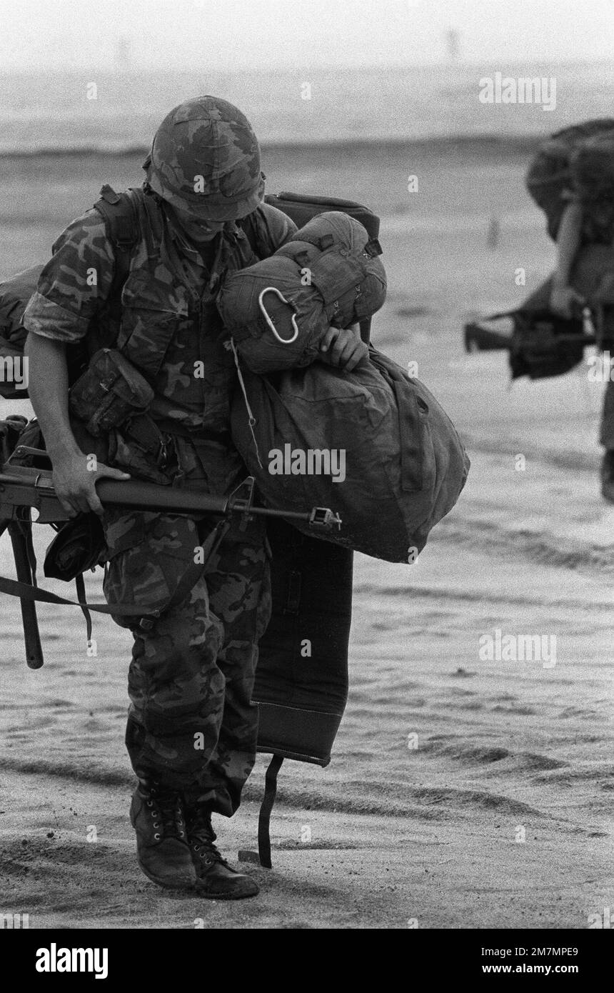 A paratrooper from the 82nd Airborne Division gathers his equipment ...