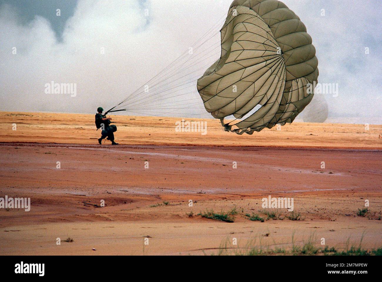 A member of the 82nd Airborne Division struggles with his parachute ...