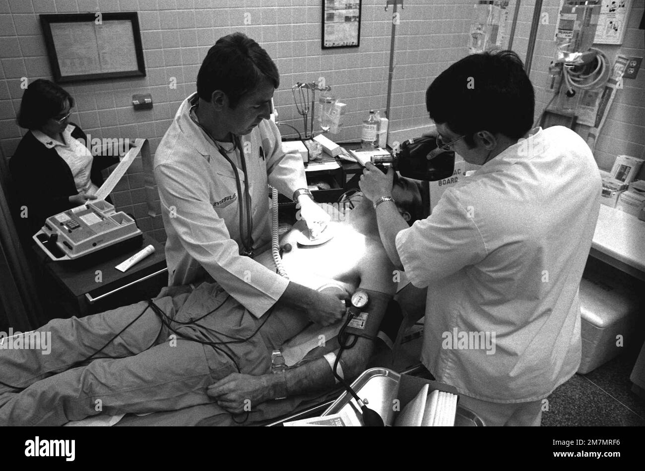 Sergeant Jean Burkley operates an EKG (electro-cardiograph) machine ...