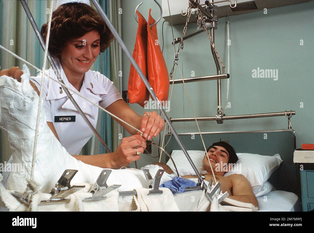 A U.S. Army nurse adjusts a traction device for a patient. Country ...