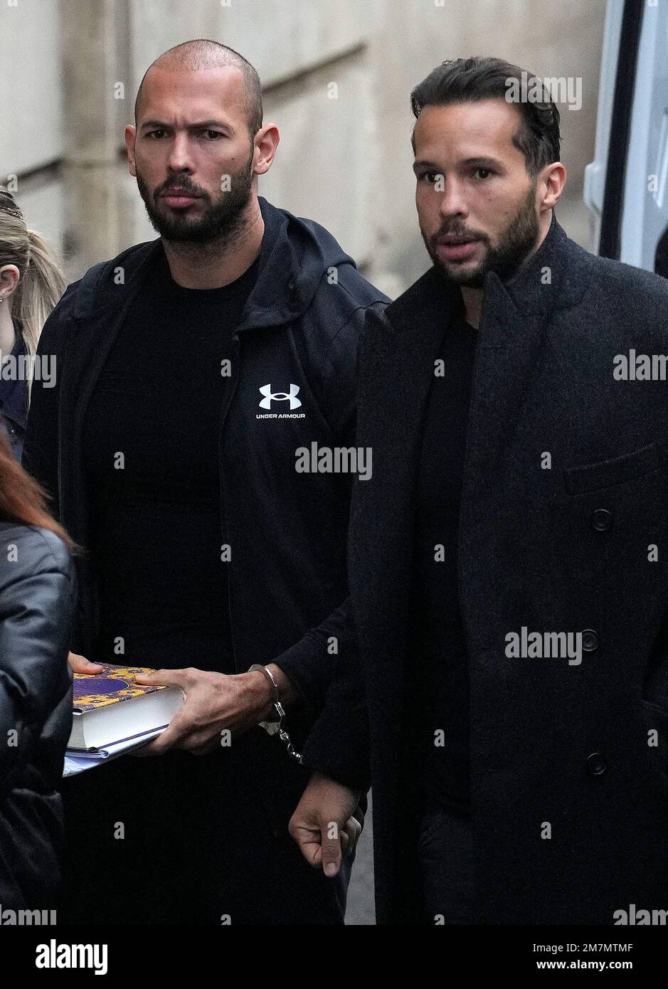 Andrew Tate, left, and his brother Tristan, right, are brought by ...