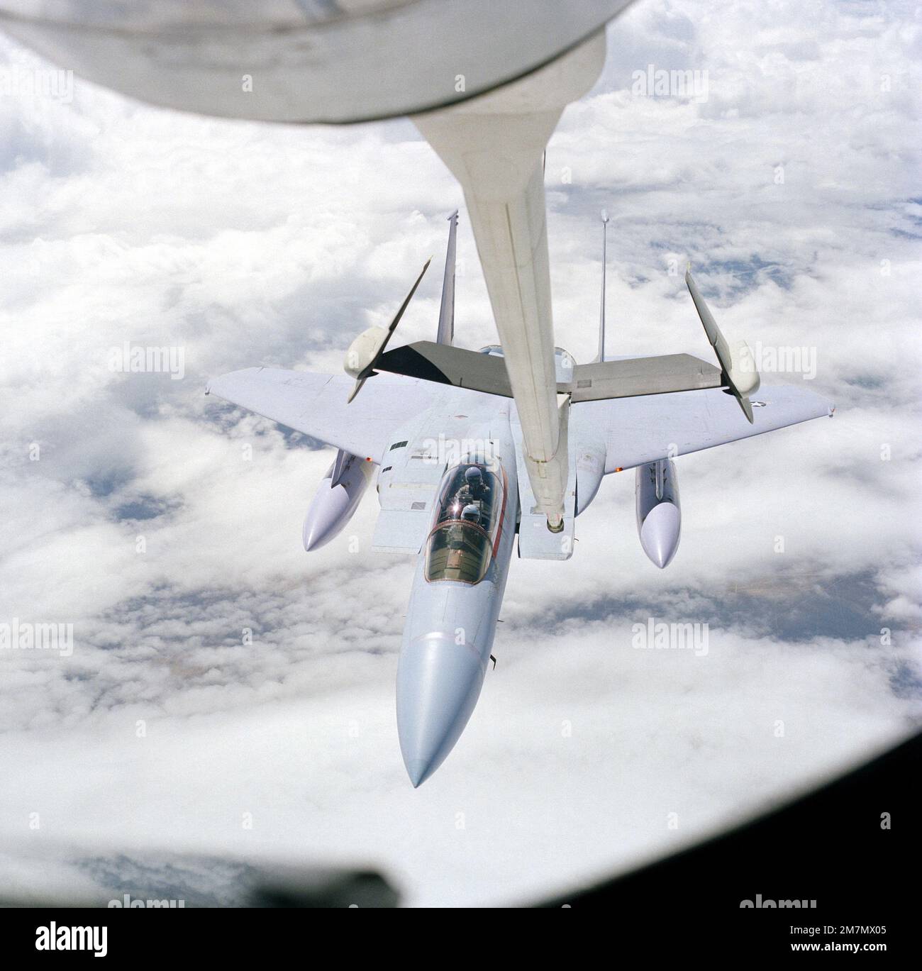An air-to-air top view of an F-15 Eagle aircraft being refueled by a KC ...