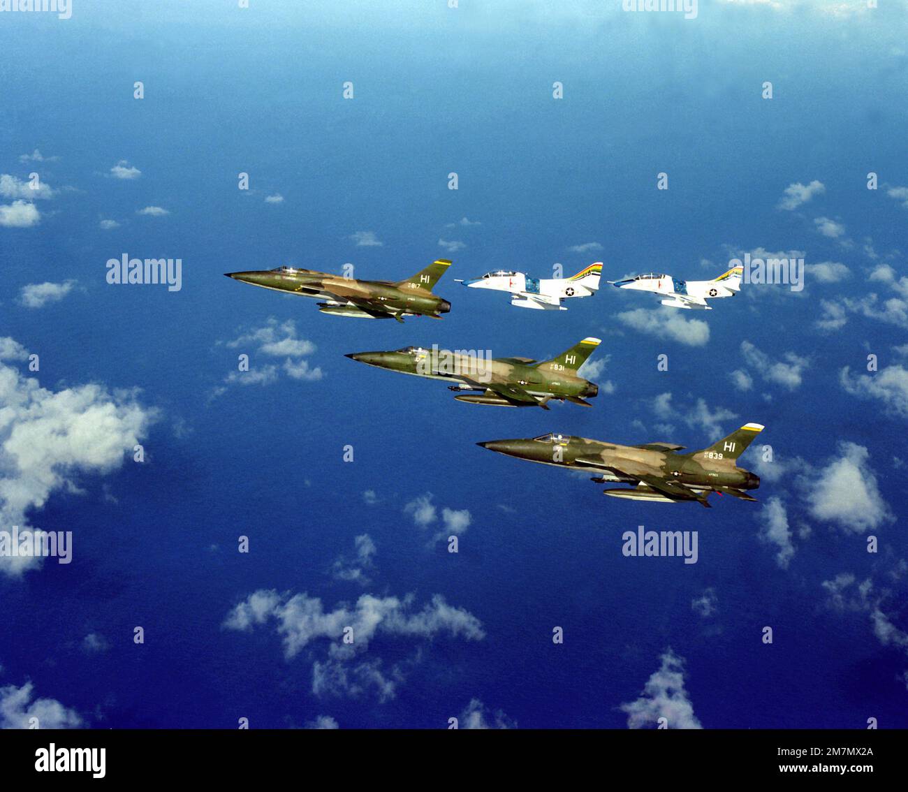 An air-to-air left side view of three F-105 Thunderchief aircraft from ...