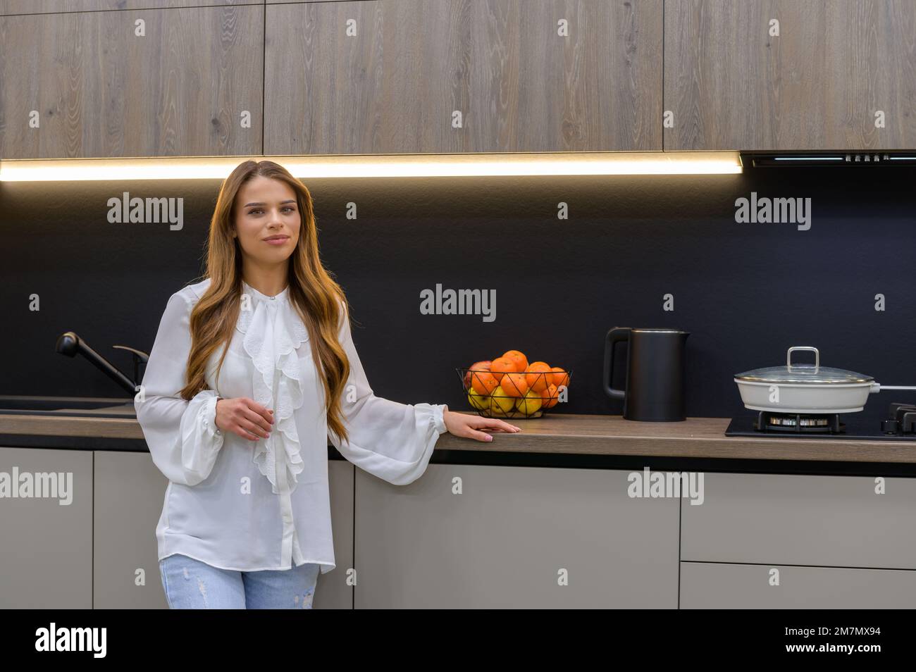 Young and pretty woman at modern grey luxurious kitchen Stock Photo - Alamy