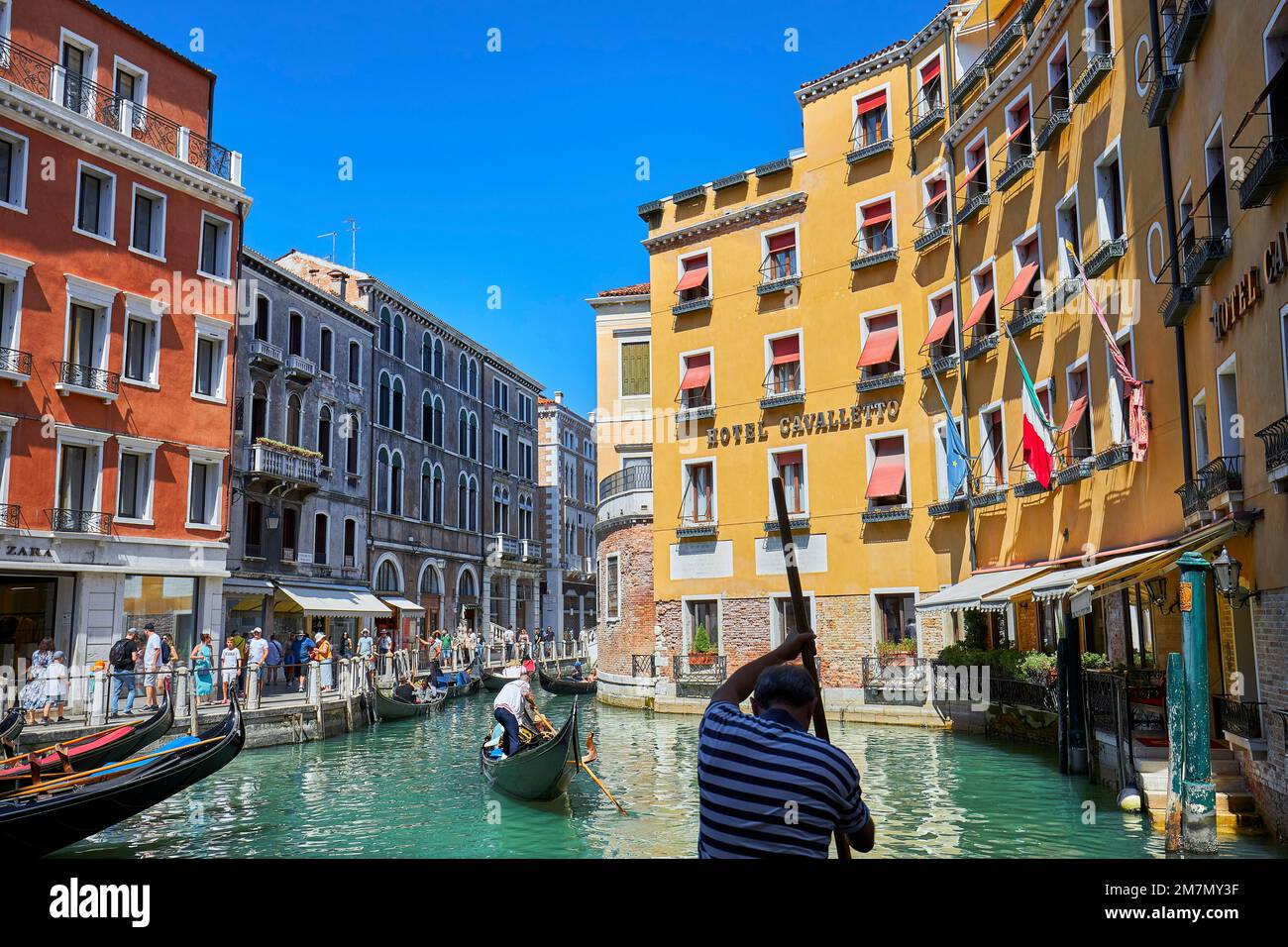 Gondoliers drive tourists through the lagoon city in Venice Stock Photo ...