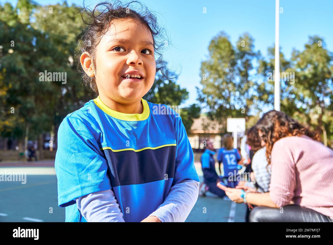 happy latin girl football player in a sport suit with on a elementary ...