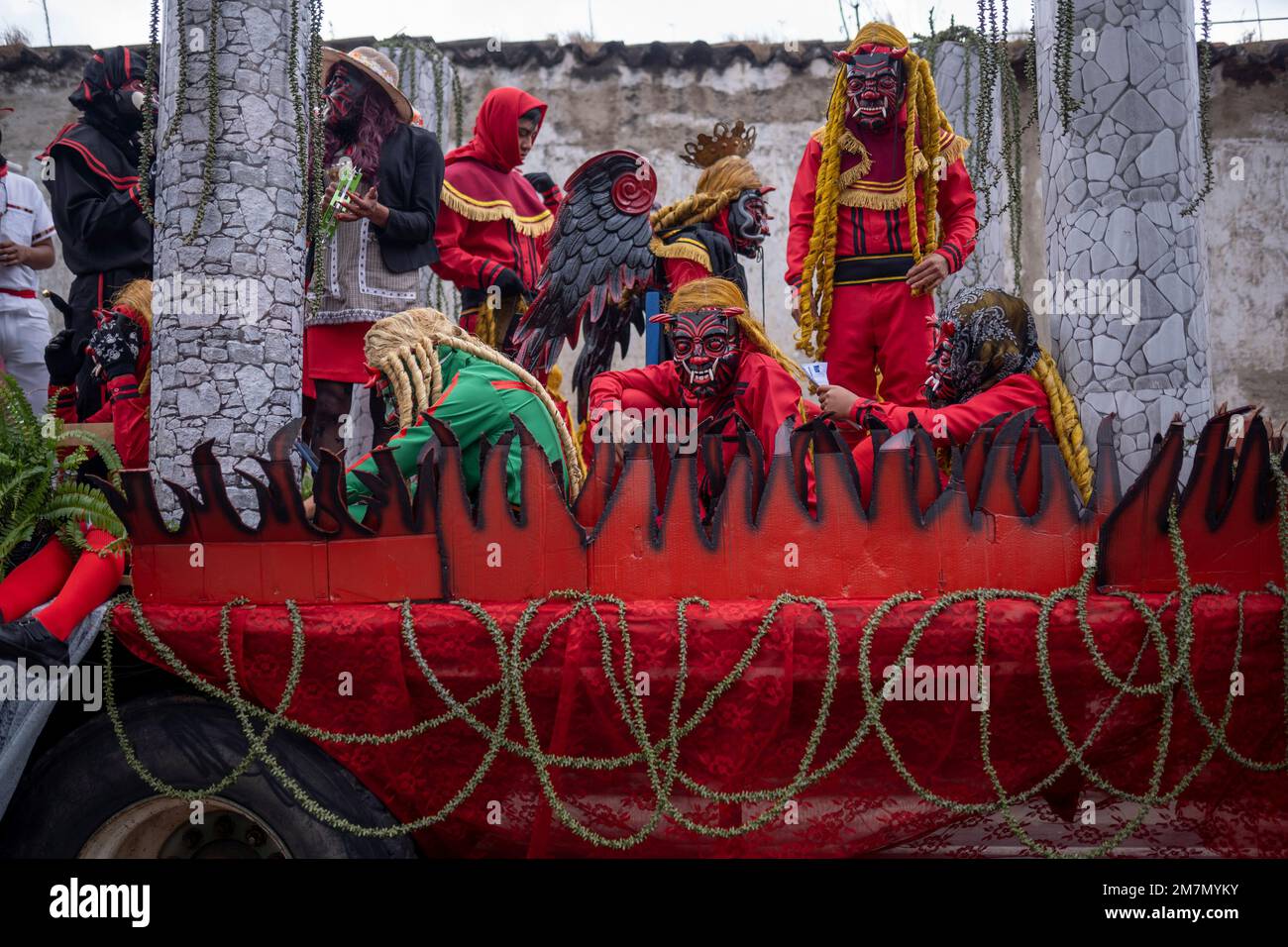 Residents dressed as devils sit in a parade float during the annual ...