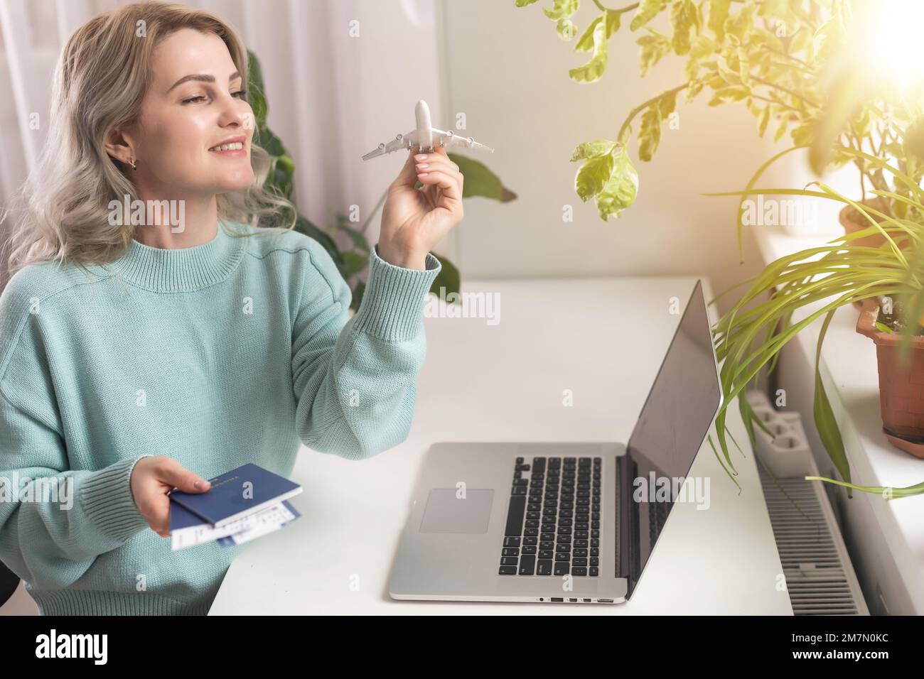 Close-up of woman hands holding model airplane and using a laptop ...