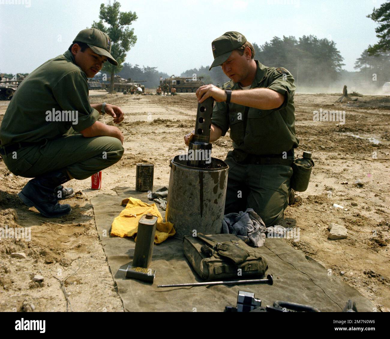 A member of the 157th Armor Division cleans the .50-caliber machine gun ...