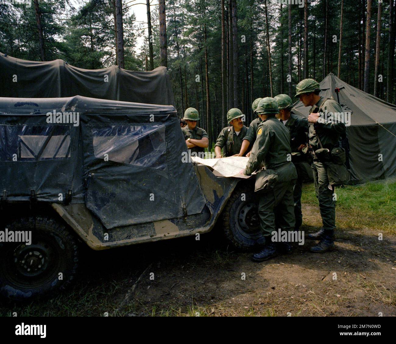 Members of the 1457th Engineer Battalion study the coordinates on a map ...