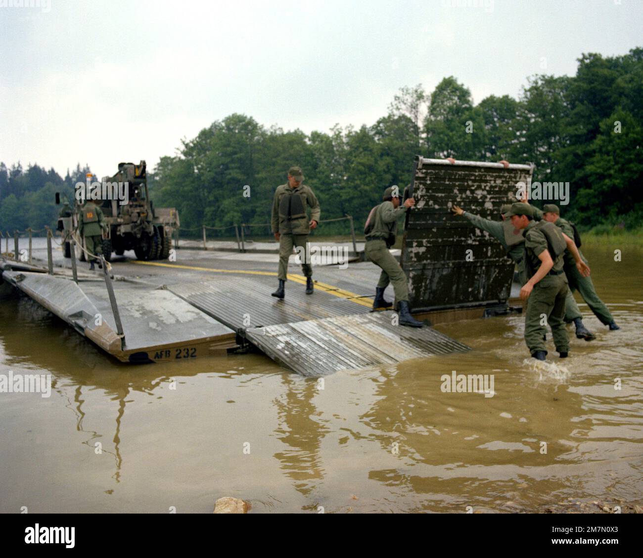 A ribbon bridge is assembled by members of the 1457th Engineer ...